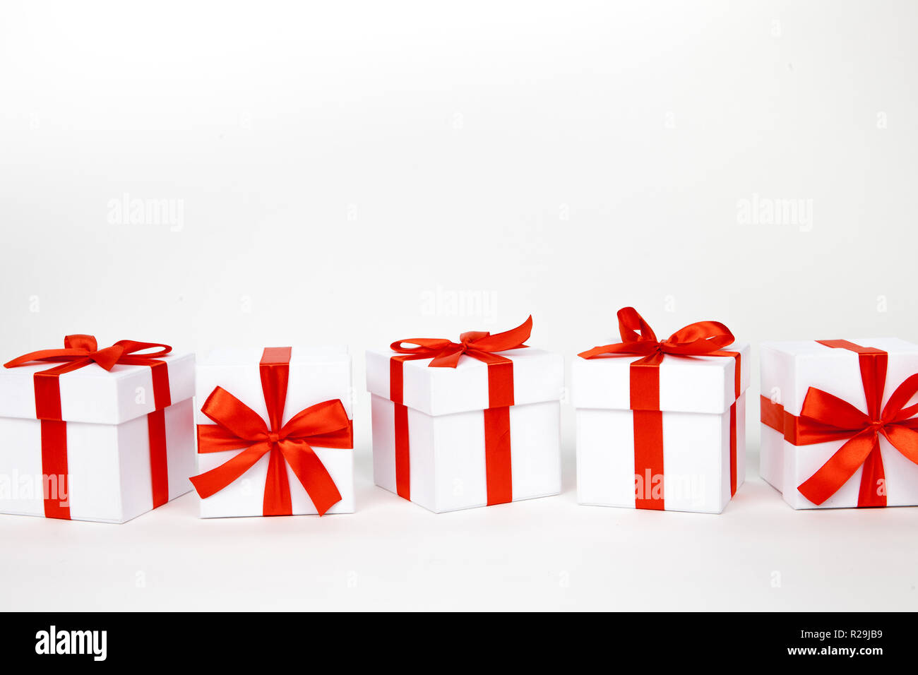 White boxes with a red satin ribbon bow Isolated on white background ...
