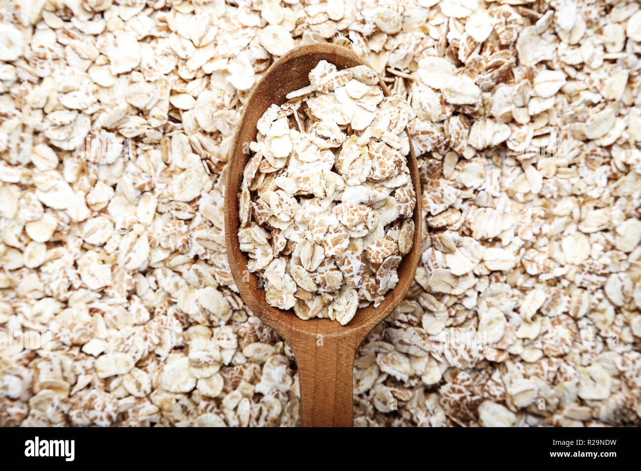 raw oatmeal flakes scattered as a background. healthy carbohydrate ...