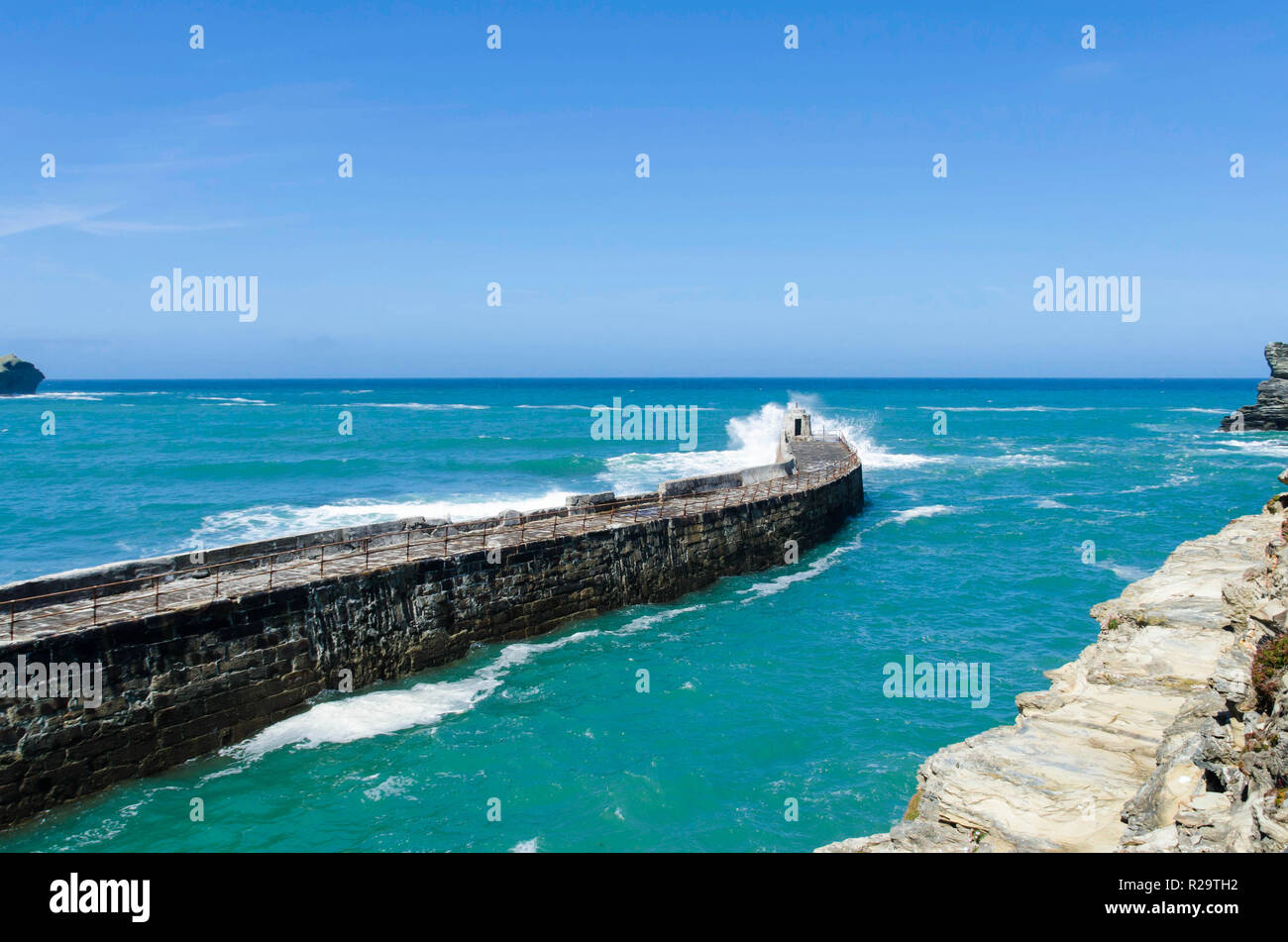 Surf breaking over the harbour wall of Portreath Cornwall UK Stock ...