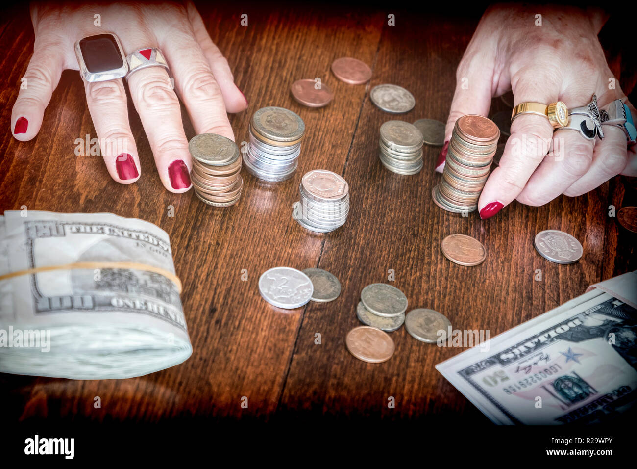 Women counting banknotes of dollar and some coins on a table ...