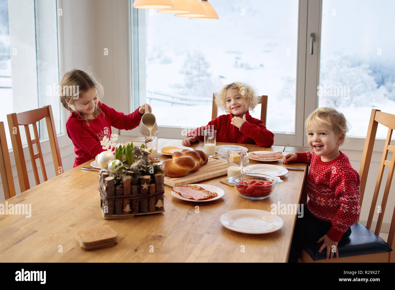 Kids having breakfast on Christmas morning. Family eating bread and ...