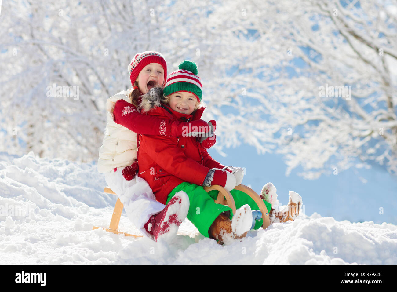 Little girl and boy enjoying sleigh ride. Child sledding. Toddler kid ...
