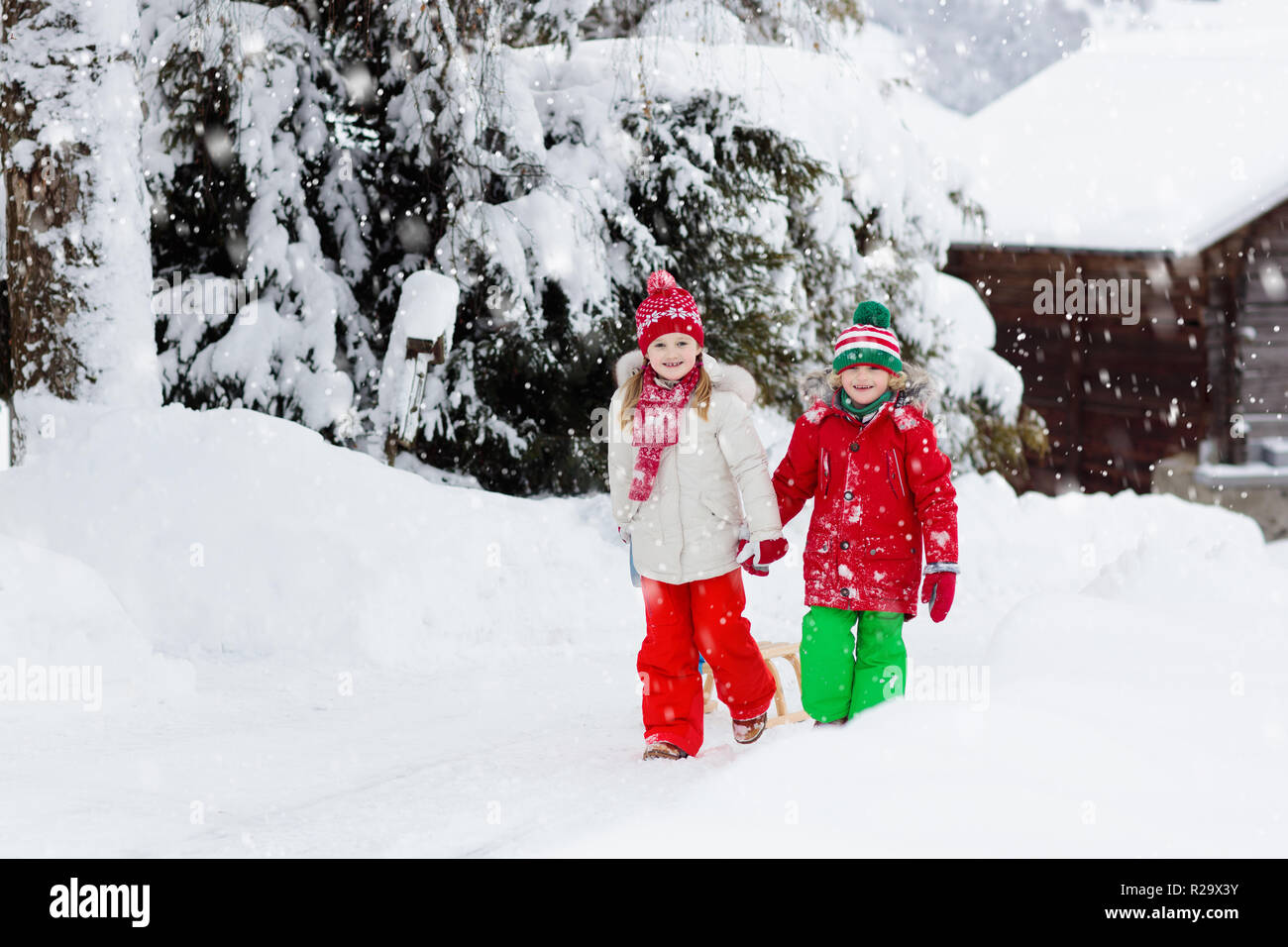 Little girl and boy enjoying sleigh ride. Child sledding. Toddler kid ...