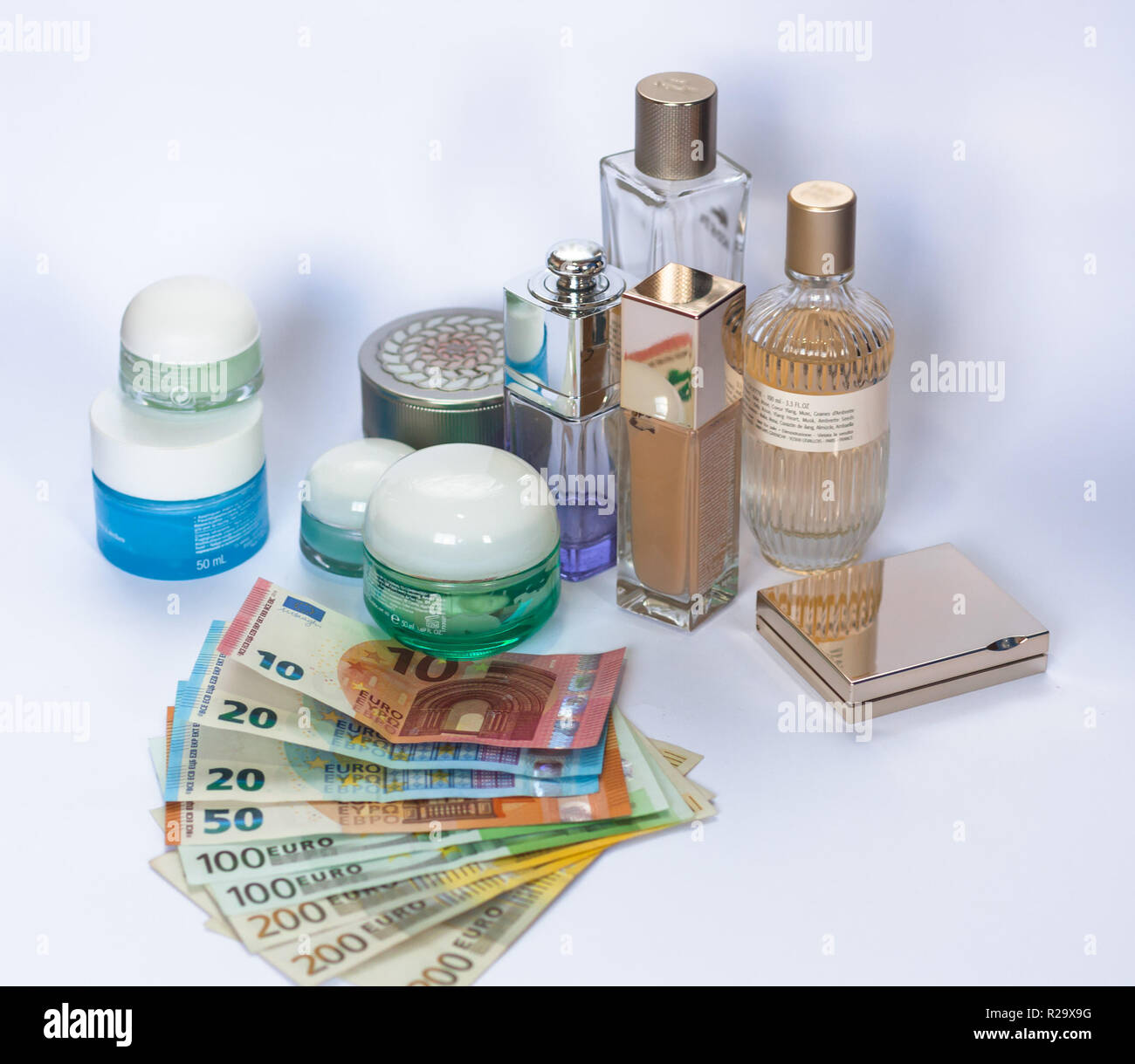 Banknote of euro and fragrance and cosmetics set on white background ...