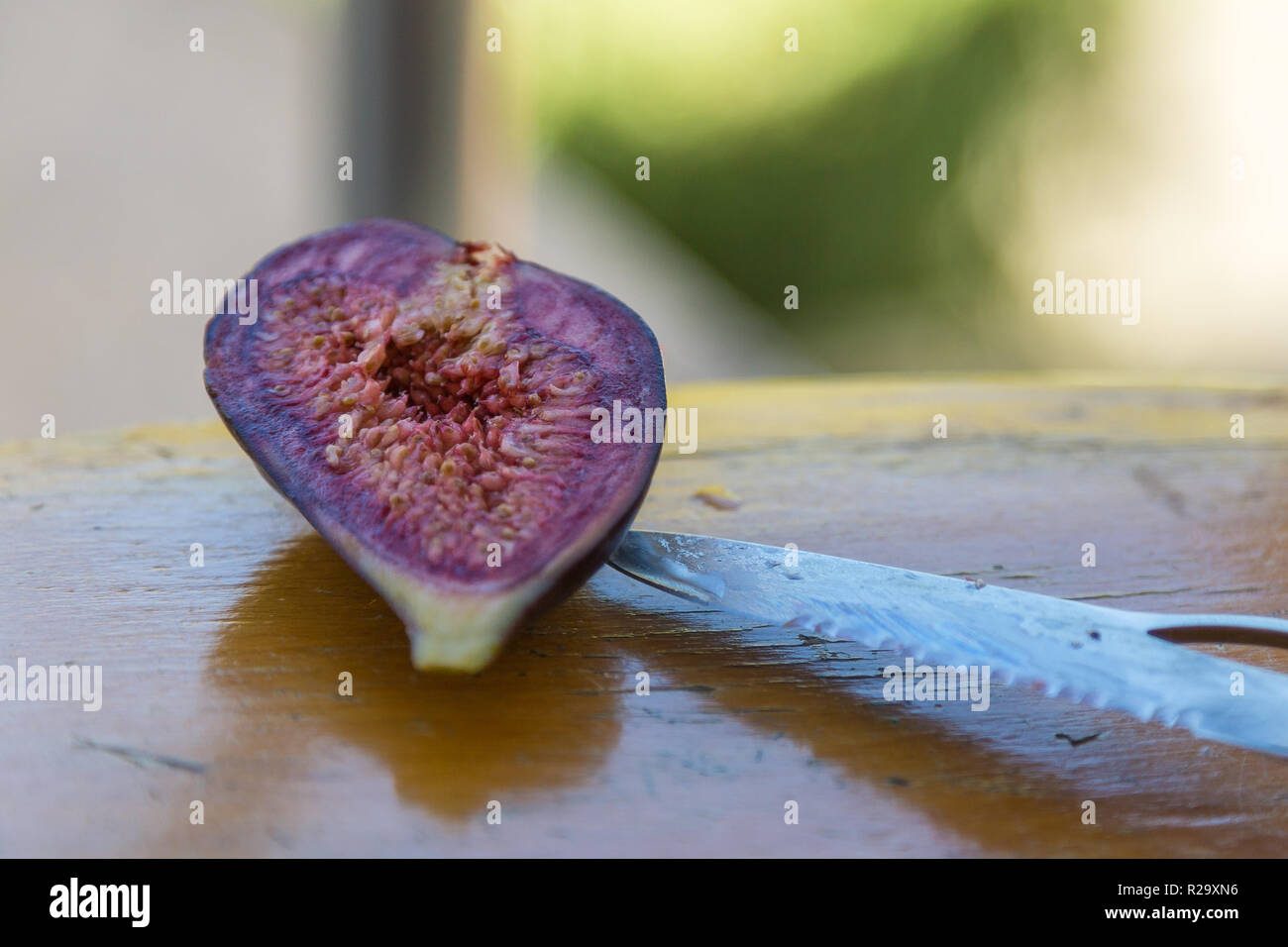 Fresh, violet, cut fig with a knife on a wooden table, Tirana, Albania ...