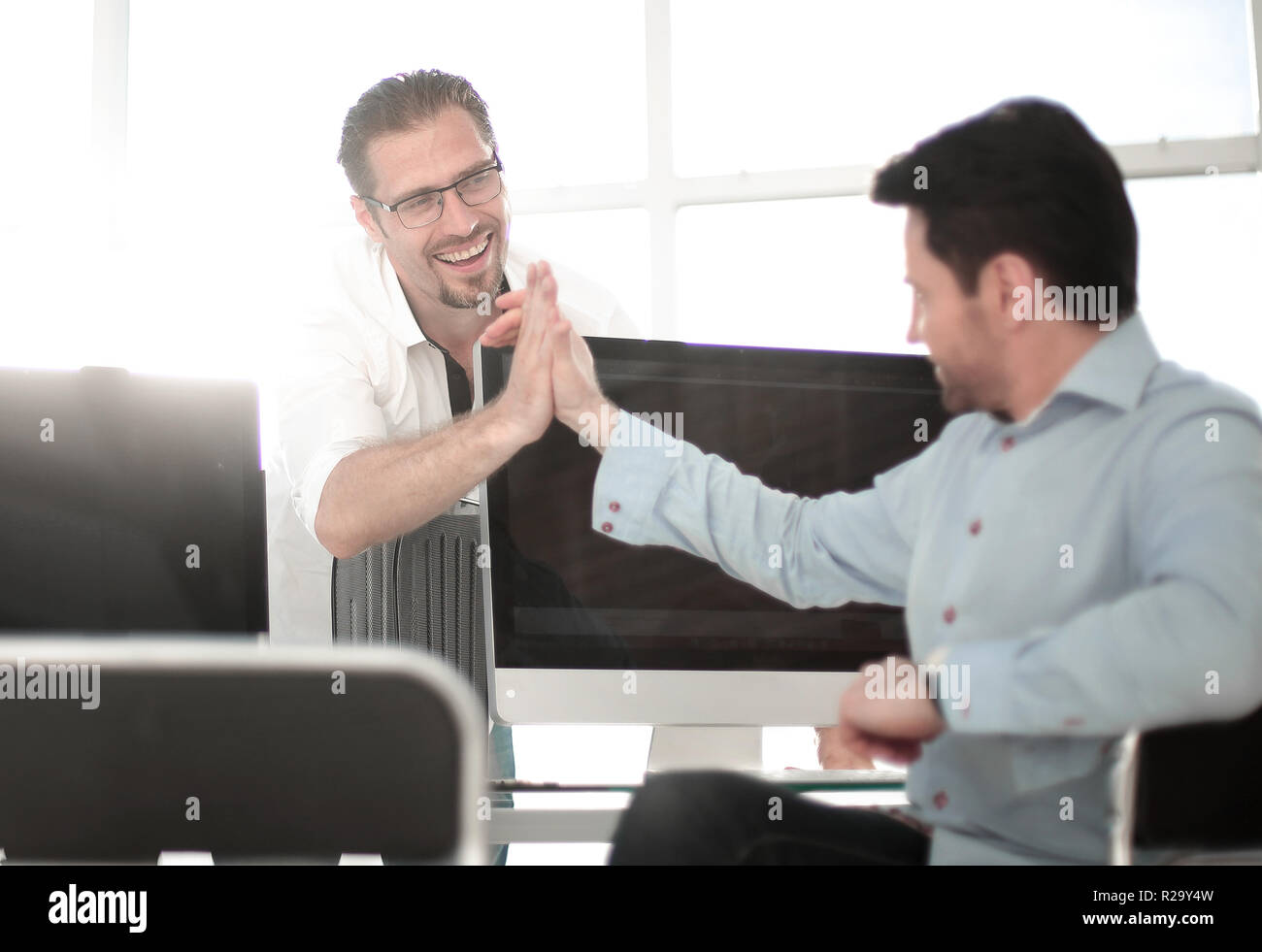 employees give each other a high five over the computer Desk Stock ...