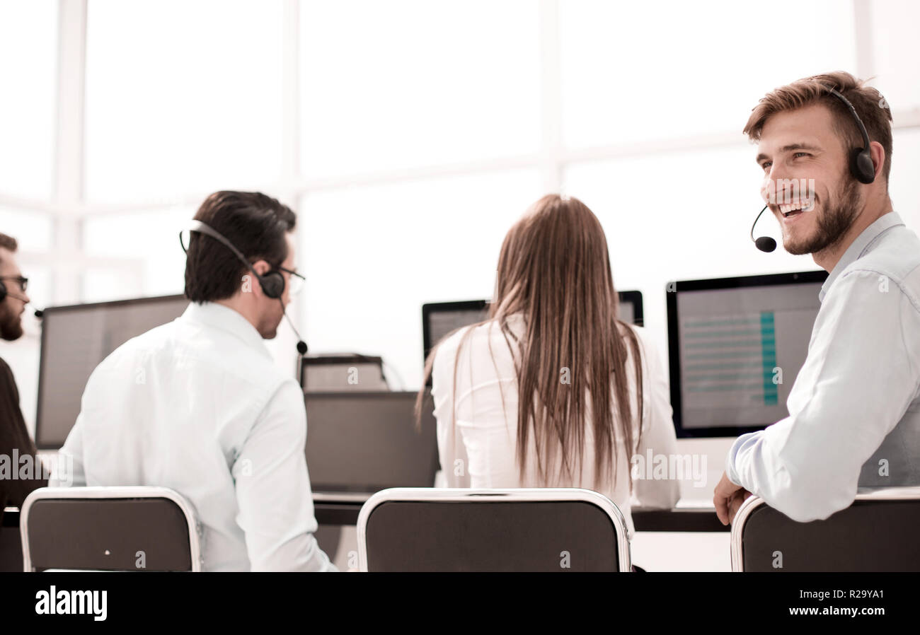 rear view. young customer service agent sitting at his Desk Stock Photo ...