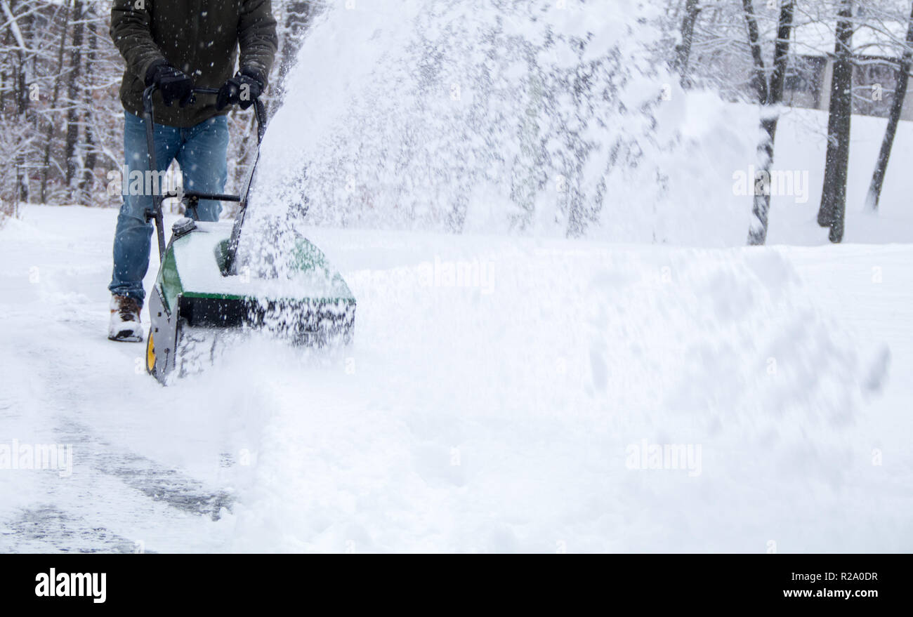 Snowblower in action during a snowstorm in the Northeast, maintaining ...