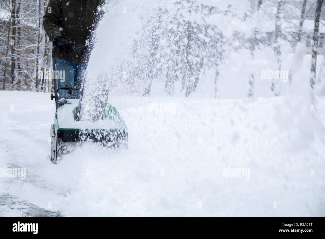 Snowblower in action during a snowstorm in the Northeast, maintaining ...
