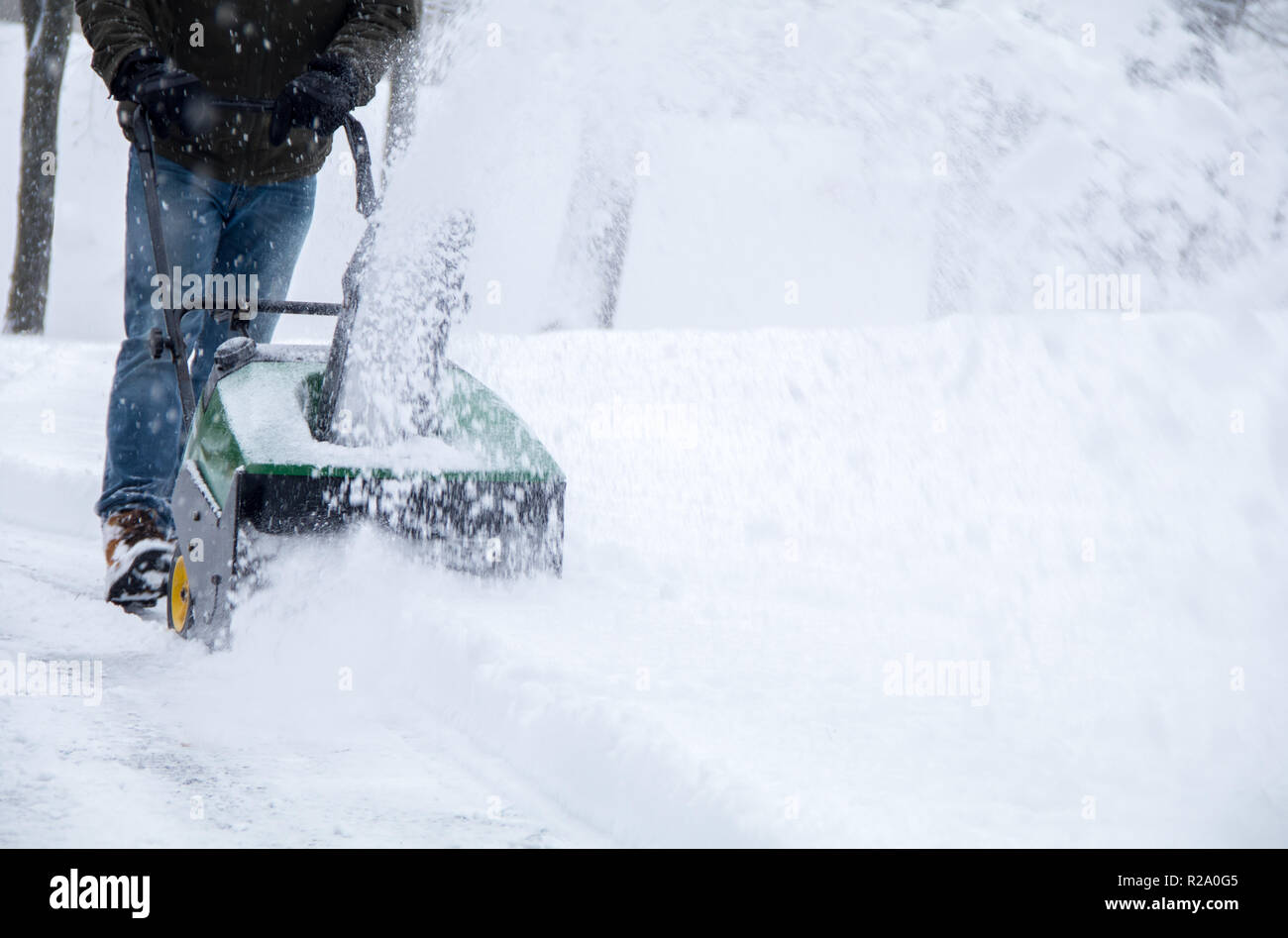 Snowblower in action during a snowstorm in the Northeast, maintaining ...