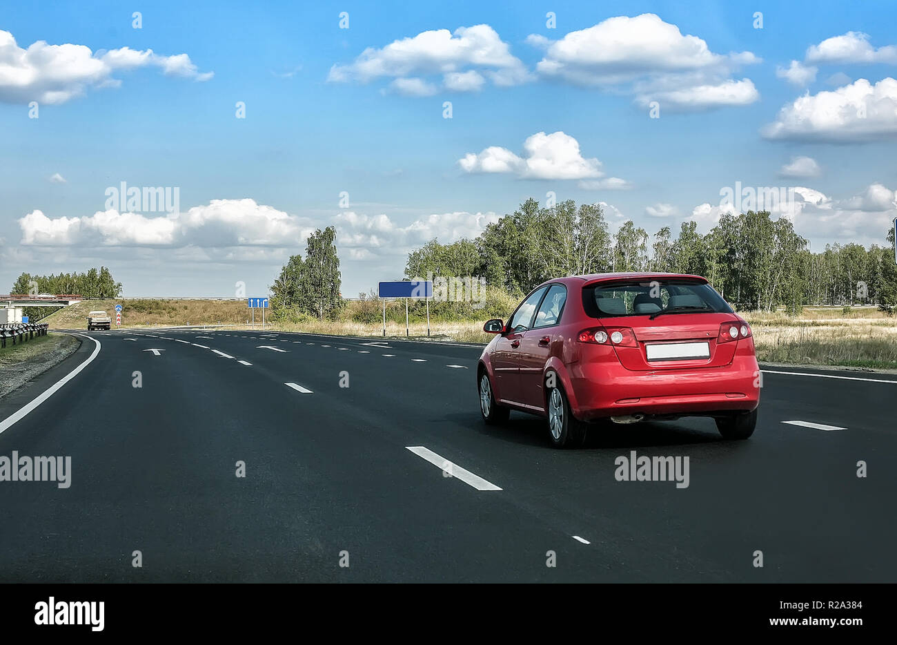 red car goes on country highway Stock Photo - Alamy