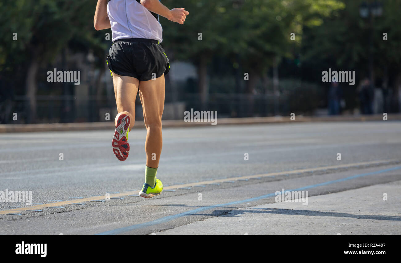 Running in the city roads. Young man runner, back view, blur background ...