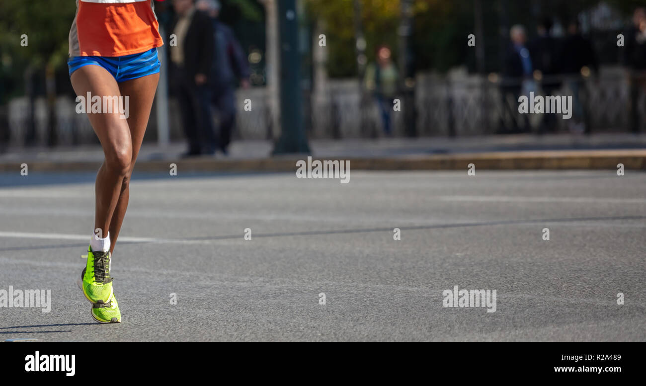 Running in the city roads. Young woman runner, front view, banner, blur ...