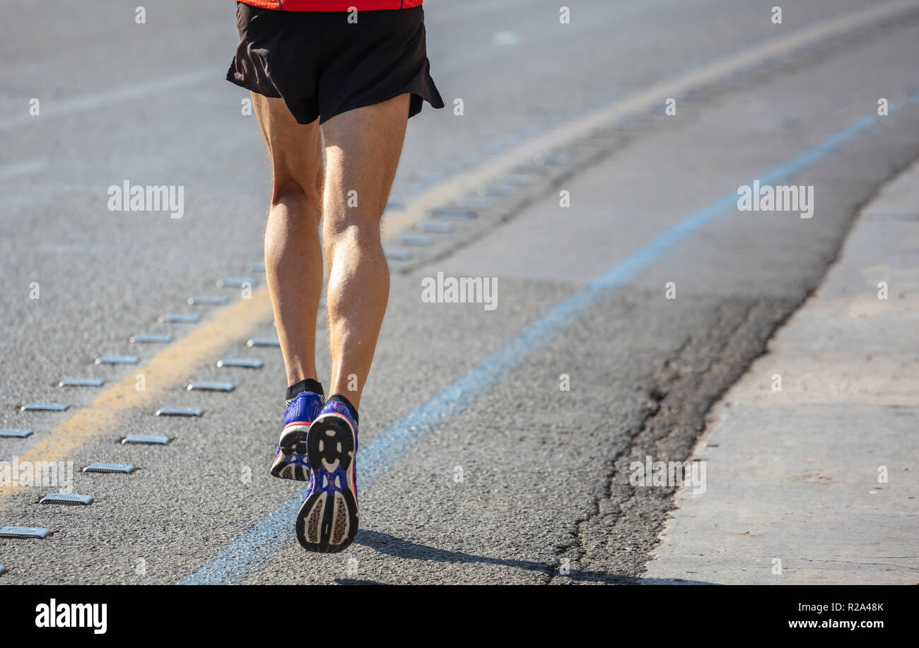 Running in the city roads. Young man runner, back view, blur background ...