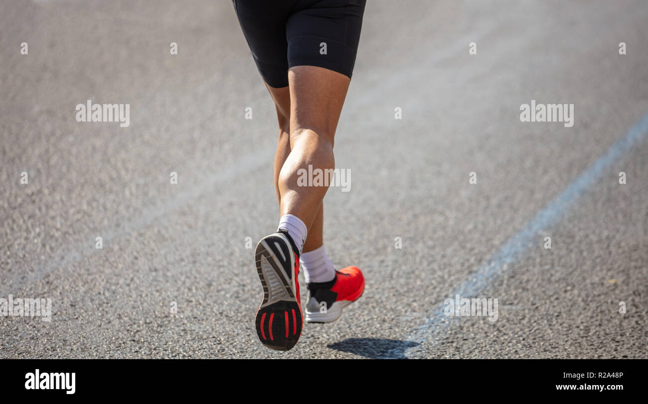 Running in the city roads. Young man runner, back view, blur background ...