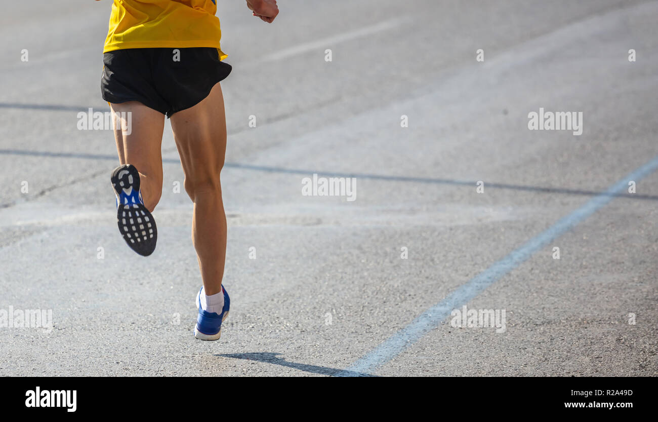 Running in the city roads. Young man runner, back view, blur background ...