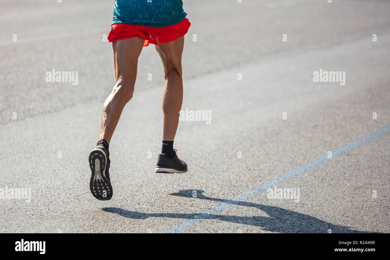 Running in the city roads. Mature man runner, back view, blur ...