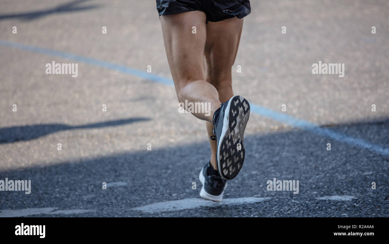 Running in the city roads. Young man runner, back view, blur background ...