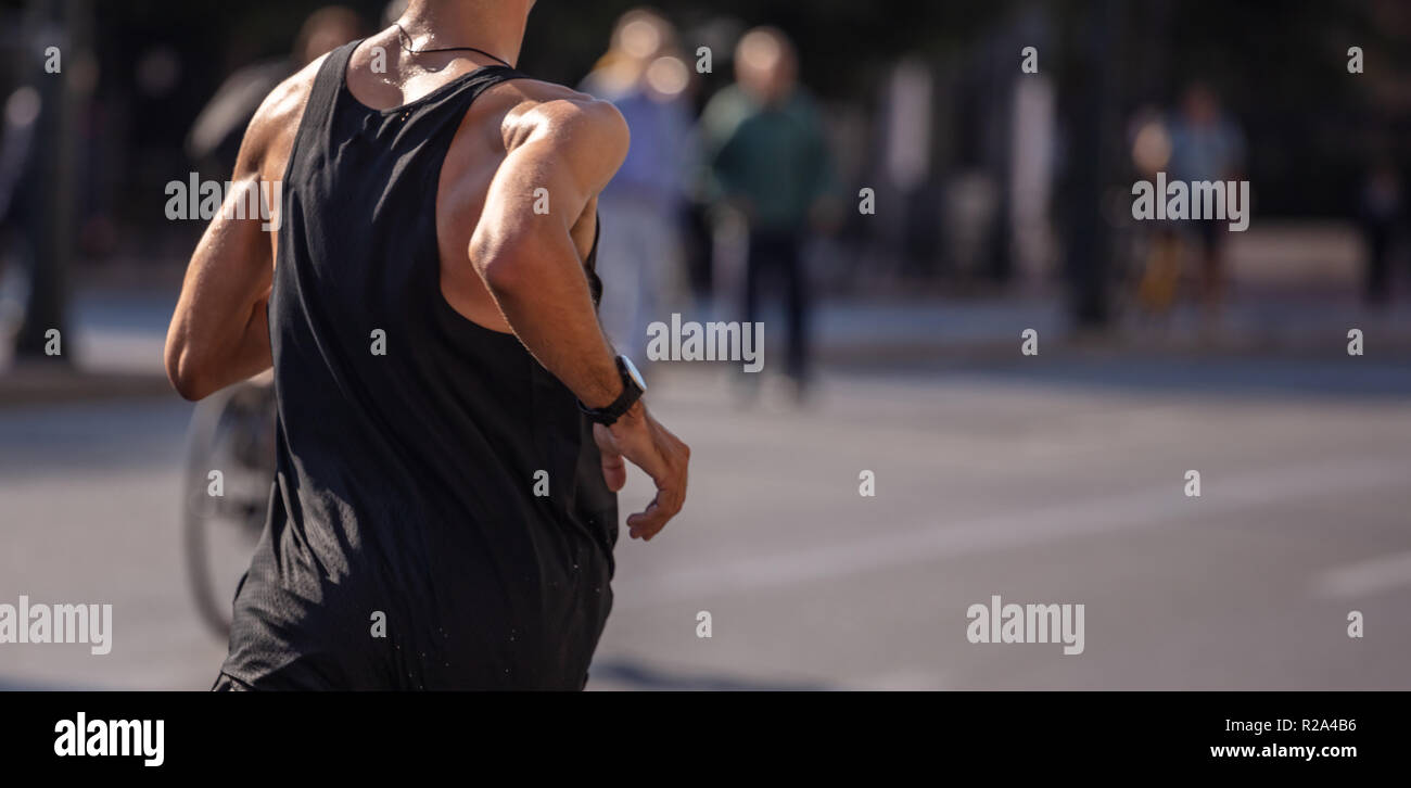 Running in the city roads. Young man runner, back view, banner, blur ...