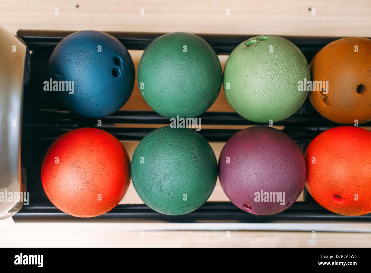 Rows of color bowling balls in feeder, top view, nobody. Bowl game ...