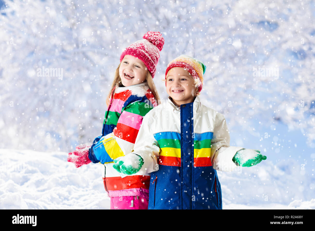 Kids playing in snow. Children play outdoors on snowy winter day. Boy ...