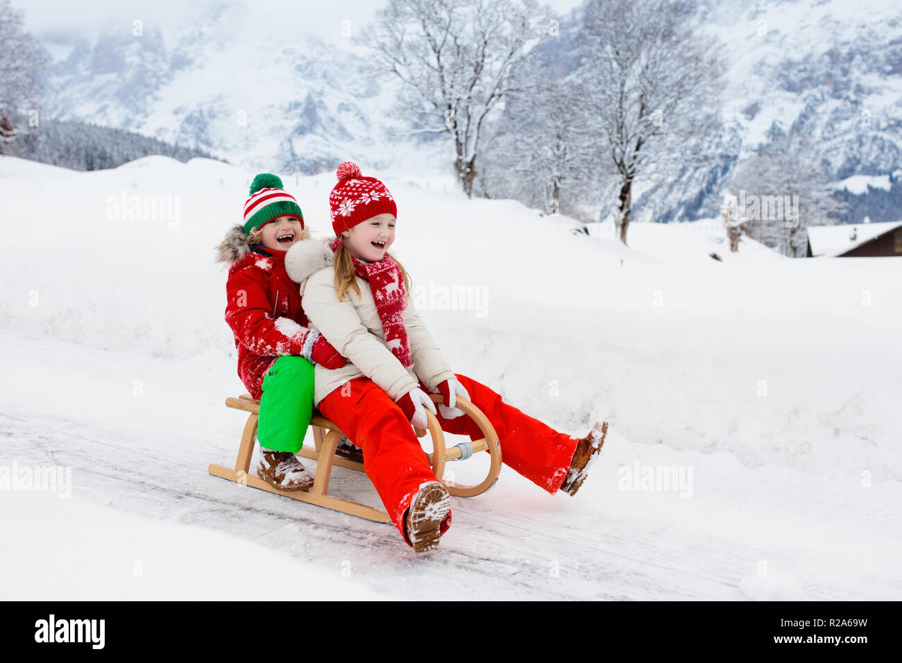 Little girl and boy enjoying sleigh ride. Child sledding. Toddler kid ...
