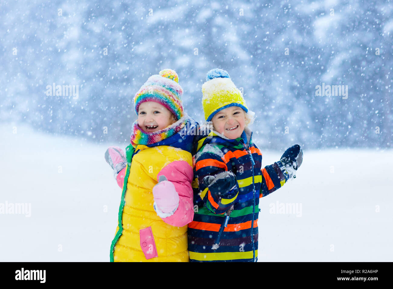 Kids playing in snow. Children play outdoors on snowy winter day. Boy ...