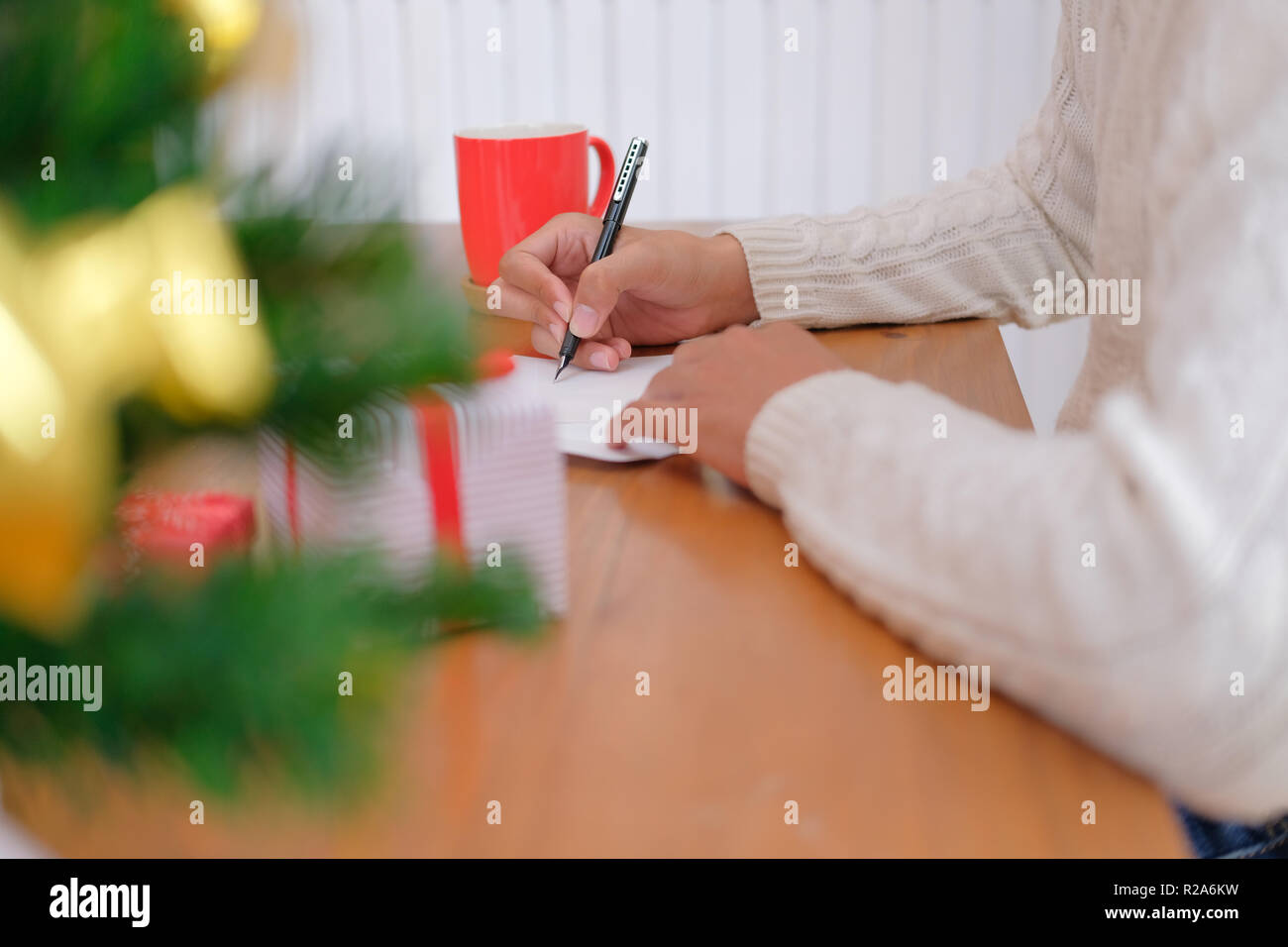 man wearing cream sweater writing christmas letter greeting card ...