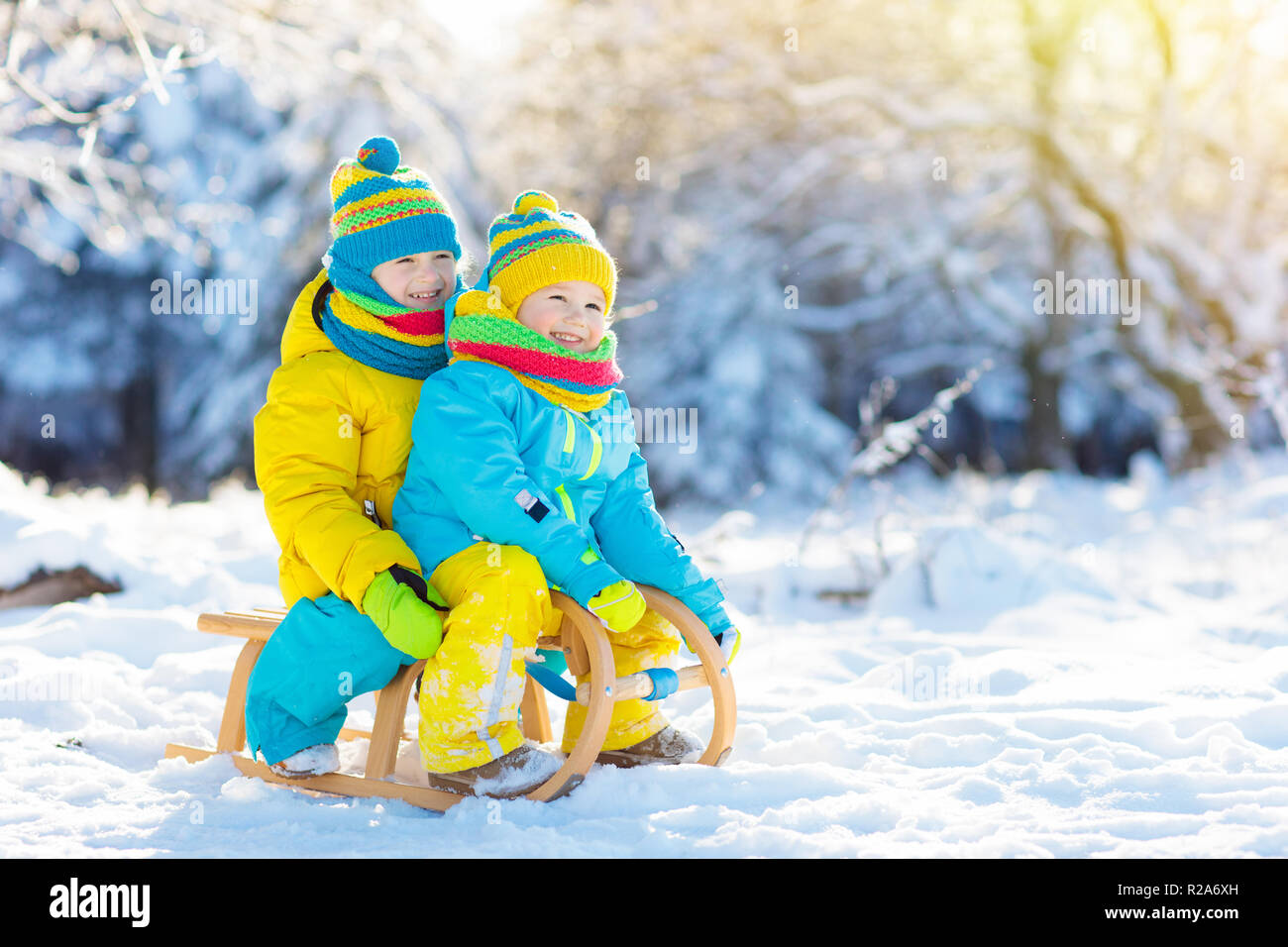 Little girl and boy enjoying sleigh ride. Child sledding. Toddler kid ...