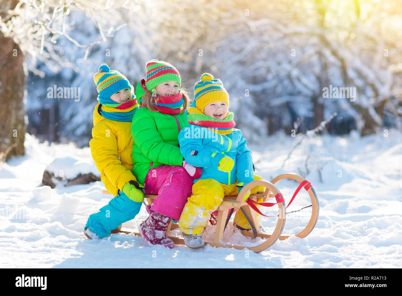 Little girl and boy enjoying sleigh ride. Child sledding. Toddler kid ...