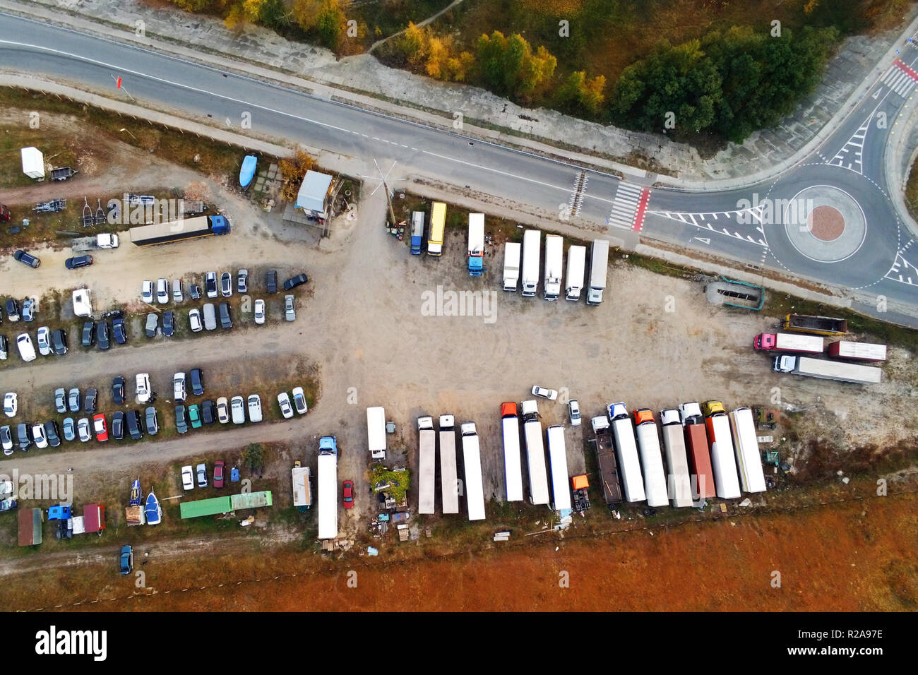 Aerial view of unpaved natural parking with lots of trucks, trailers ...