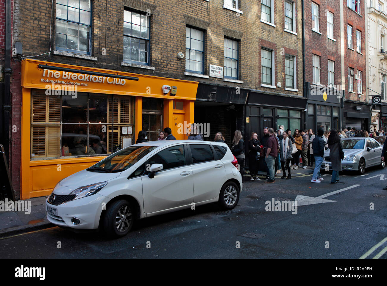 a long queue of people waiting to eat brunch at The Breakfast Club 33 D ...
