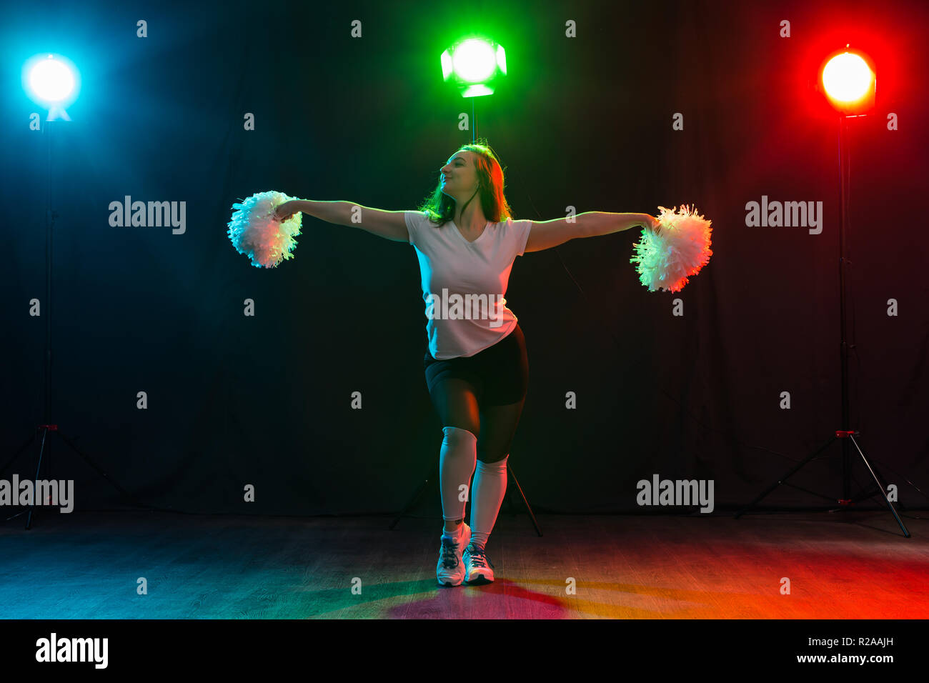 Cheerleading happy girl dancing on dark background Stock Photo - Alamy