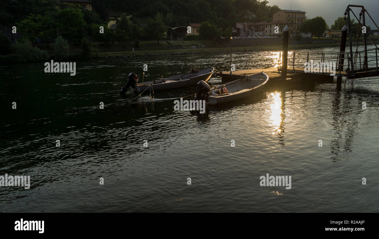 Lake Como, source of the river Adda and a pier with moored boats Stock ...