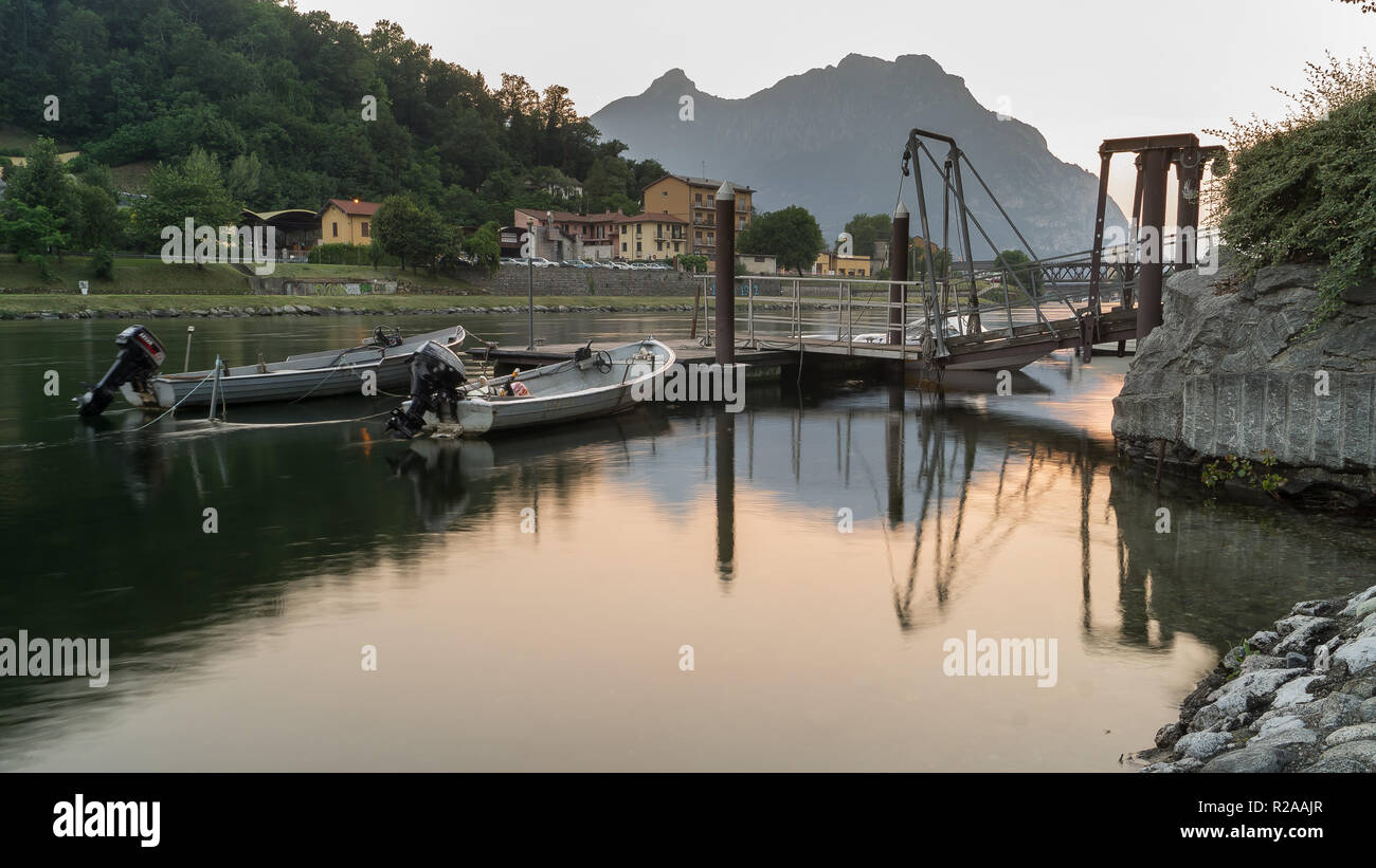Lake Como, source of the river Adda and a pier with moored boats Stock ...