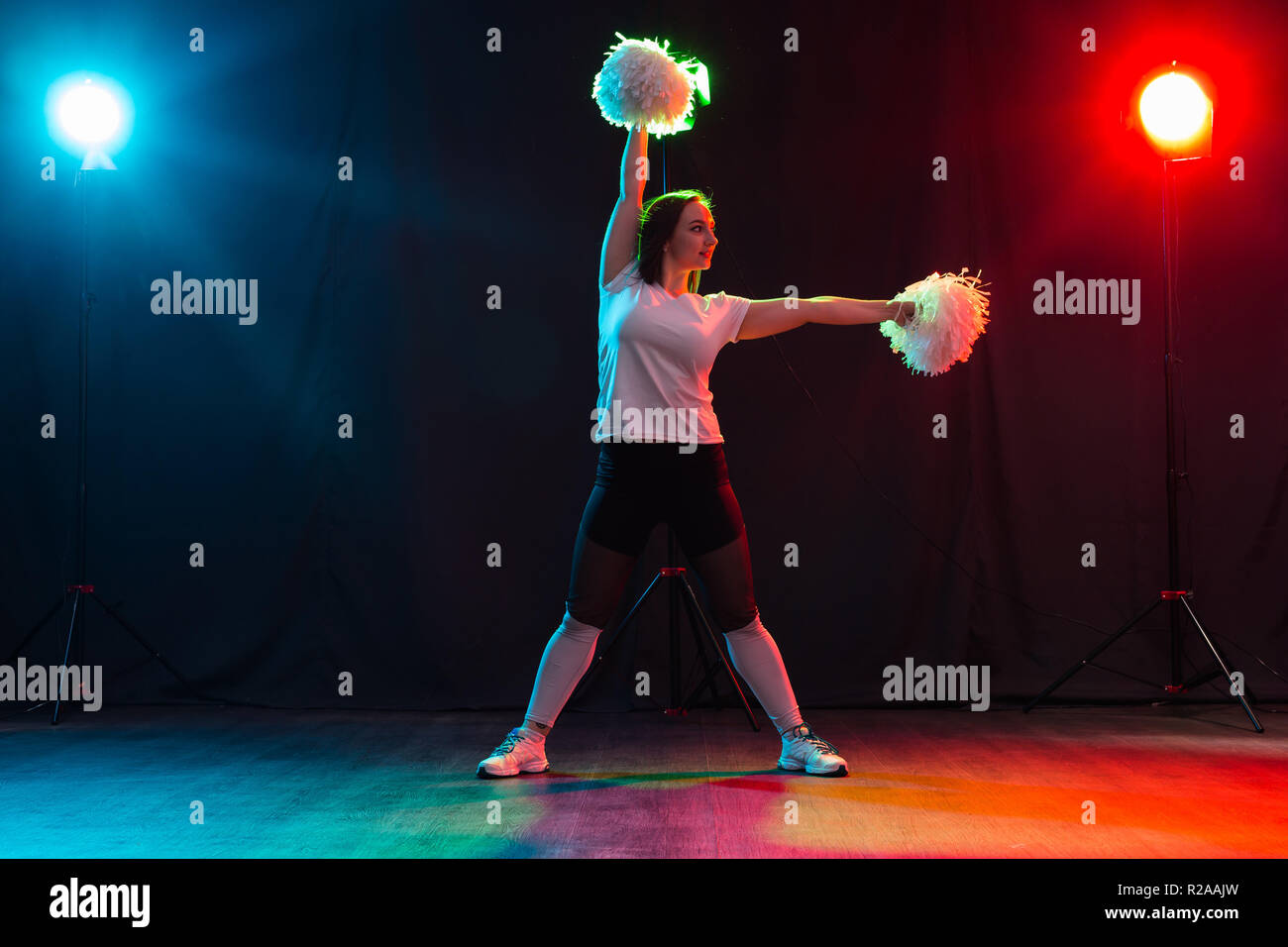 Full length portrait of cheerleader dancing with pom-poms Stock Photo ...