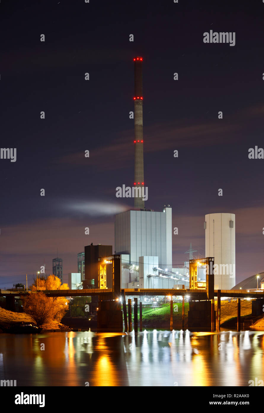 An old coal power station with reflection in the water at night, a ...