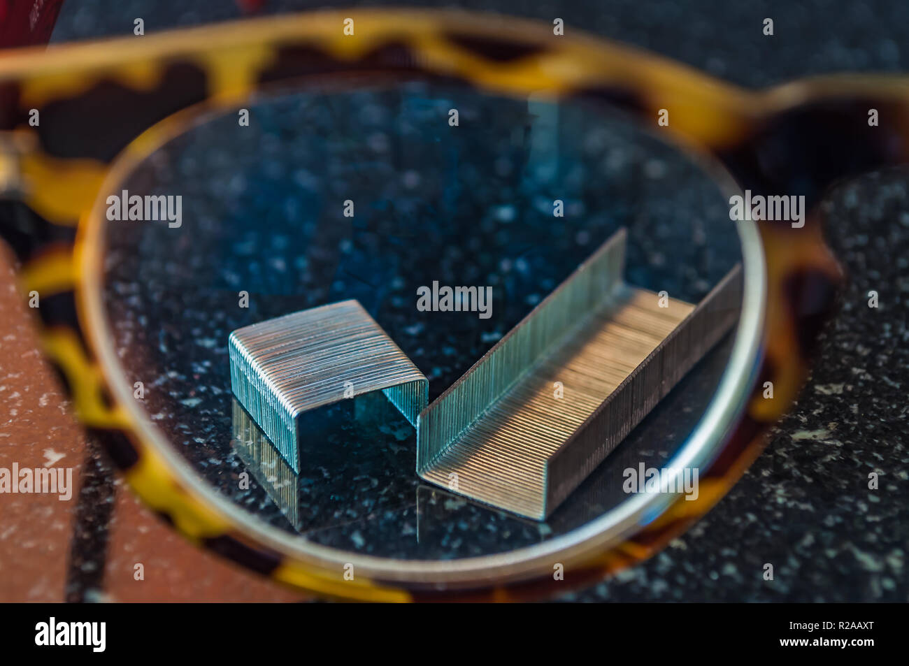 metal staples through reading glasses Stock Photo - Alamy