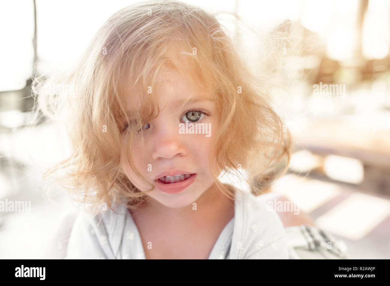 Close-up portrait of pretty young little blond pale unhappy moody ...