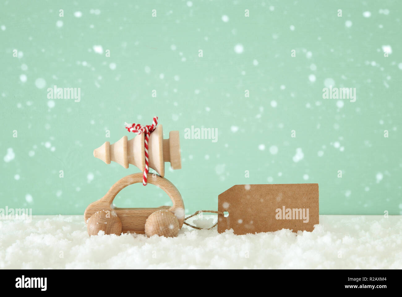 Wooden car carrying a christmas tree in front of pastel background ...