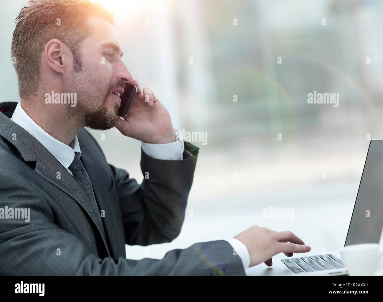closeup.businessman working on laptop and talking on the phone Stock ...