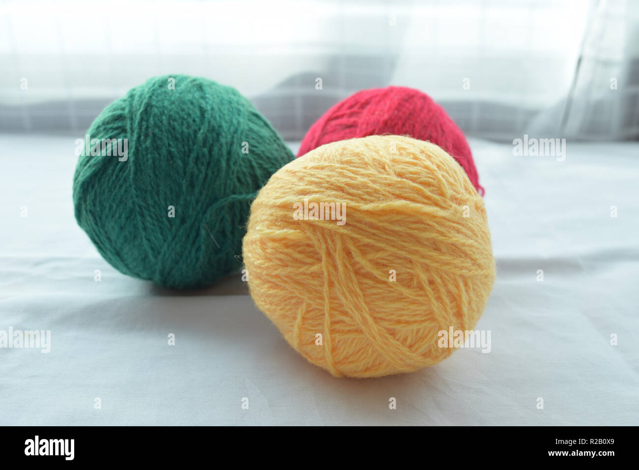 colored yarn for knitting on a light background Stock Photo - Alamy