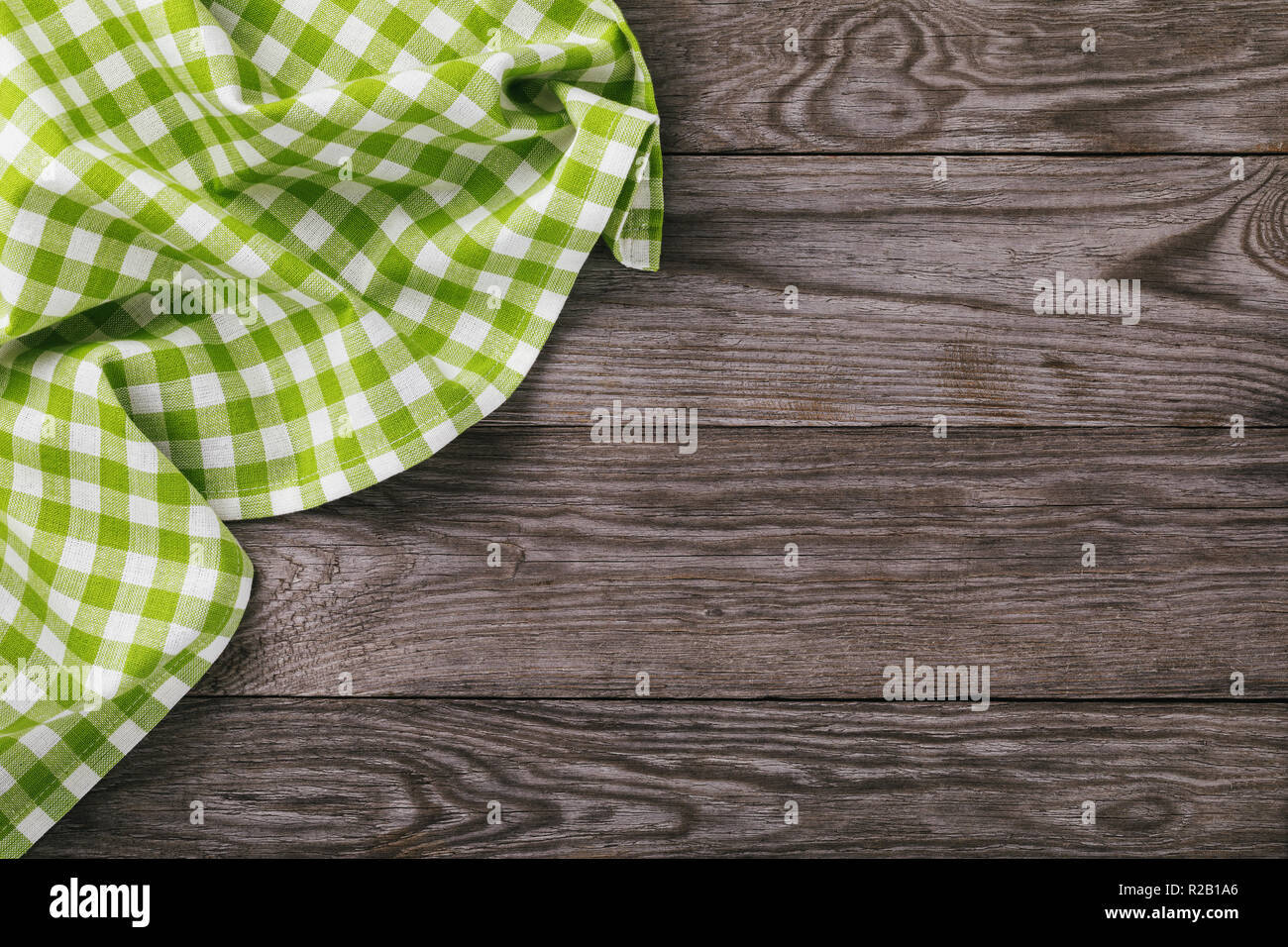 Top view on a multi-colored napkin on the left side of a wooden table ...