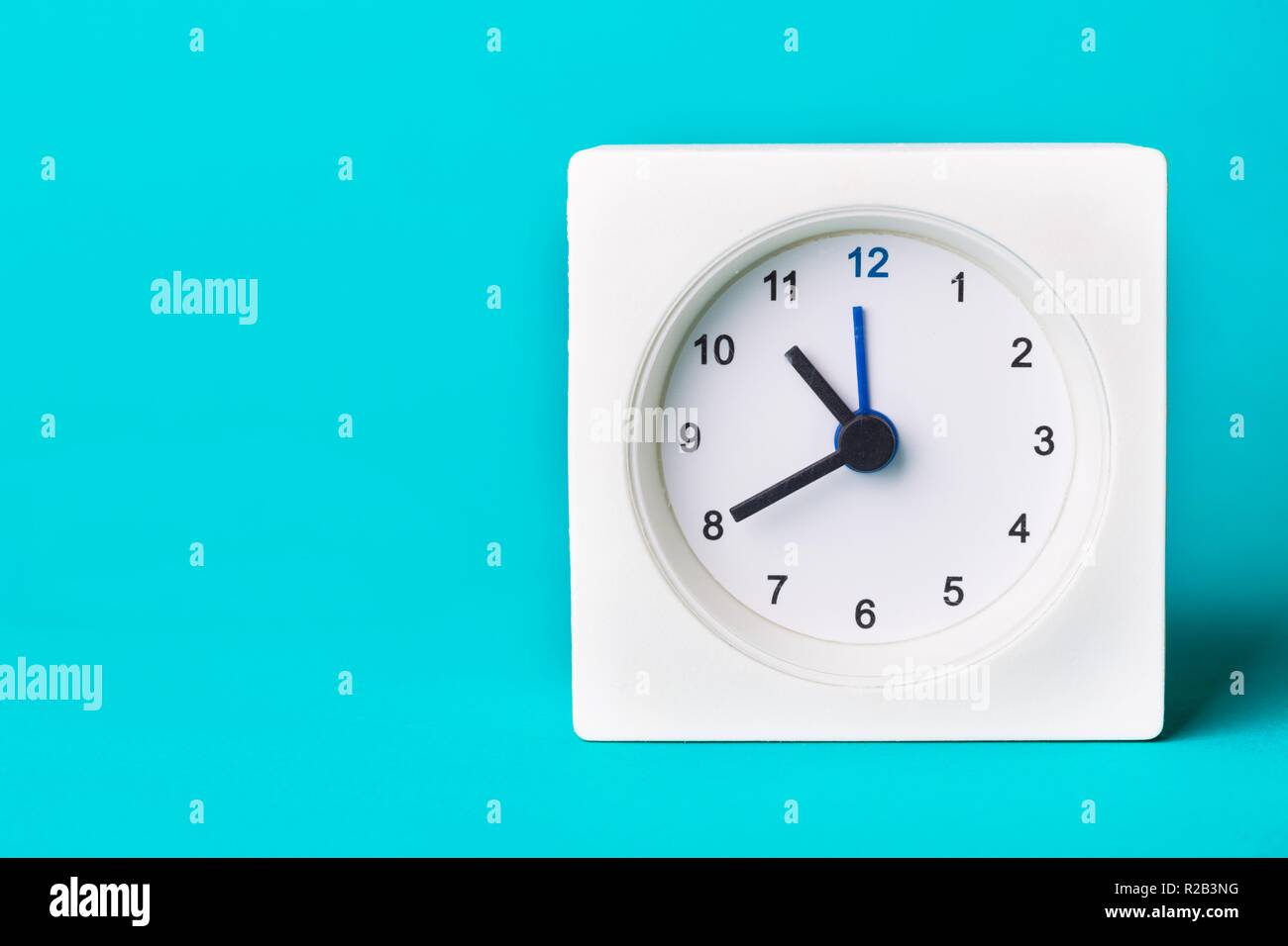 small square white clock on a blue background Stock Photo - Alamy