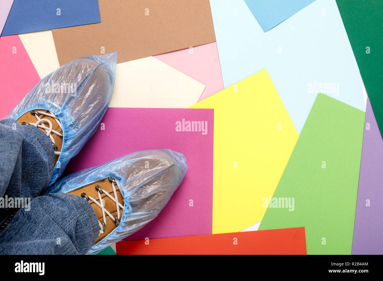 men's feet in shoe covers on multi-colored paper sheets Stock Photo - Alamy