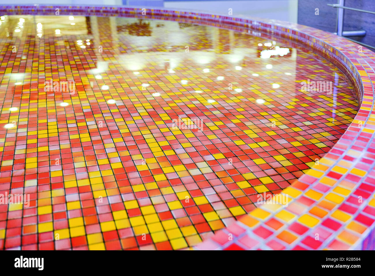 water in the pool with red-orange decorative tiles Stock Photo - Alamy