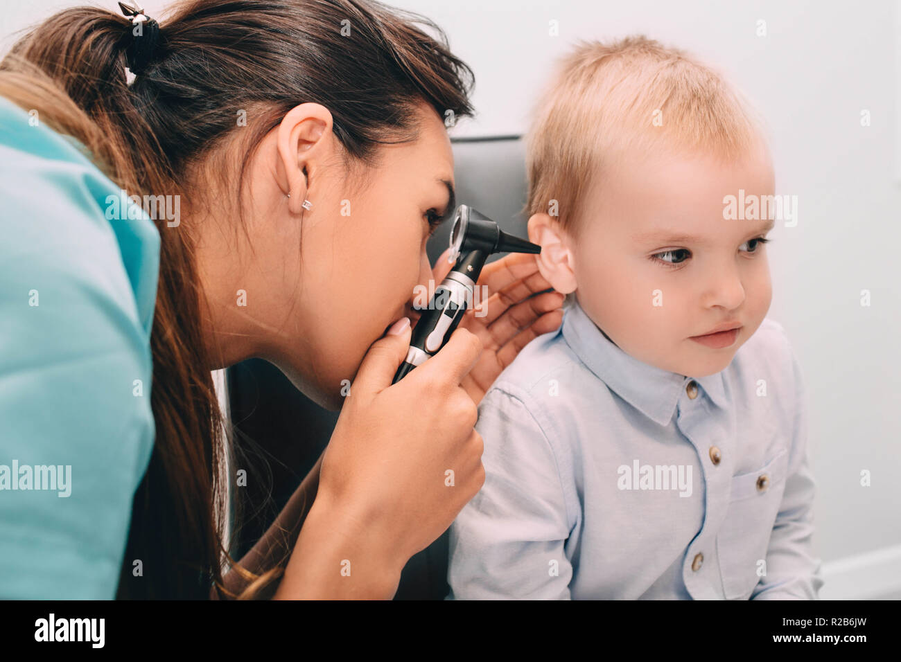 ENT doctor doing an ear exam with otoscope to little boy Stock Photo ...
