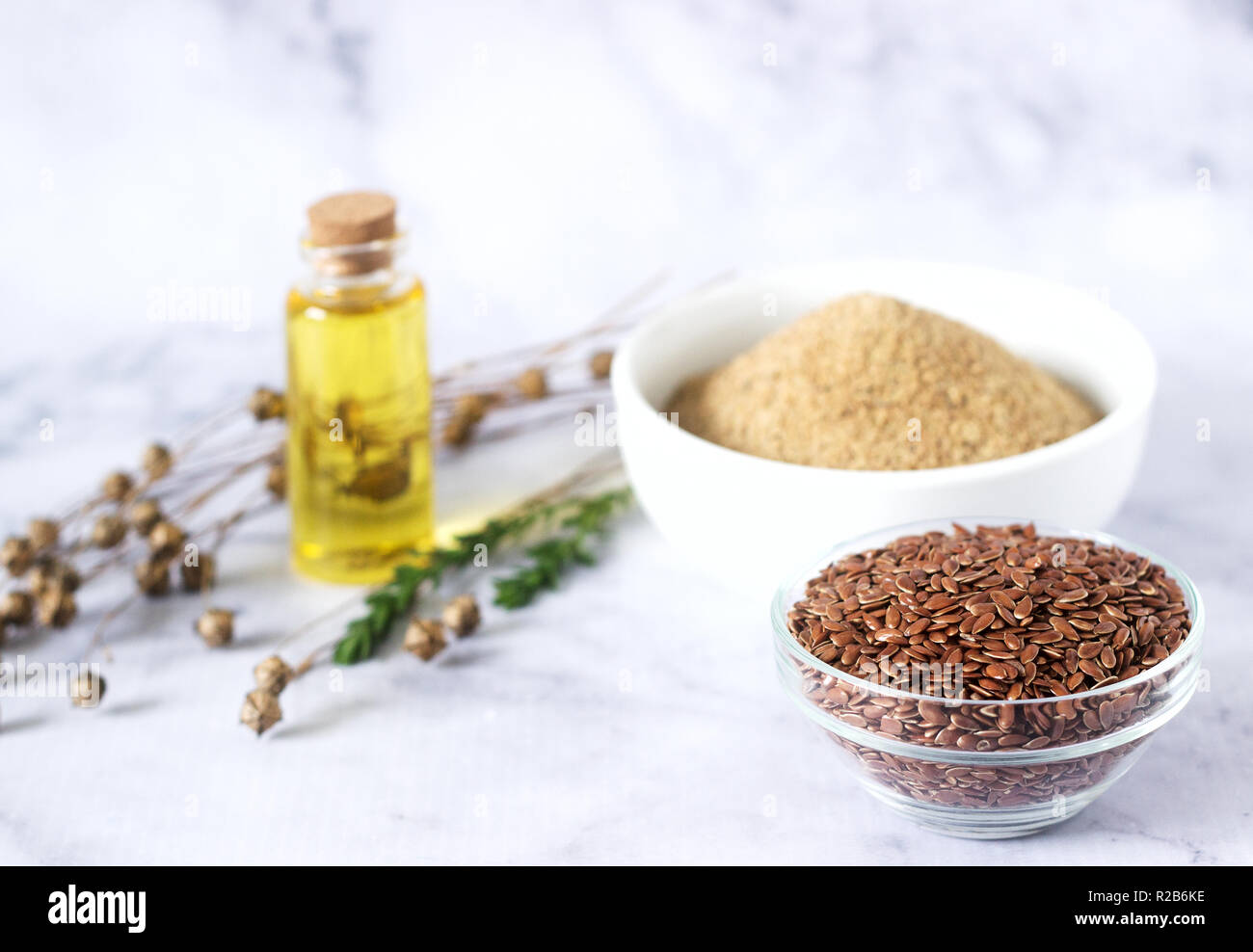 Flax seeds, flax flour, oil with sprouts and flax seed boxes on a light ...