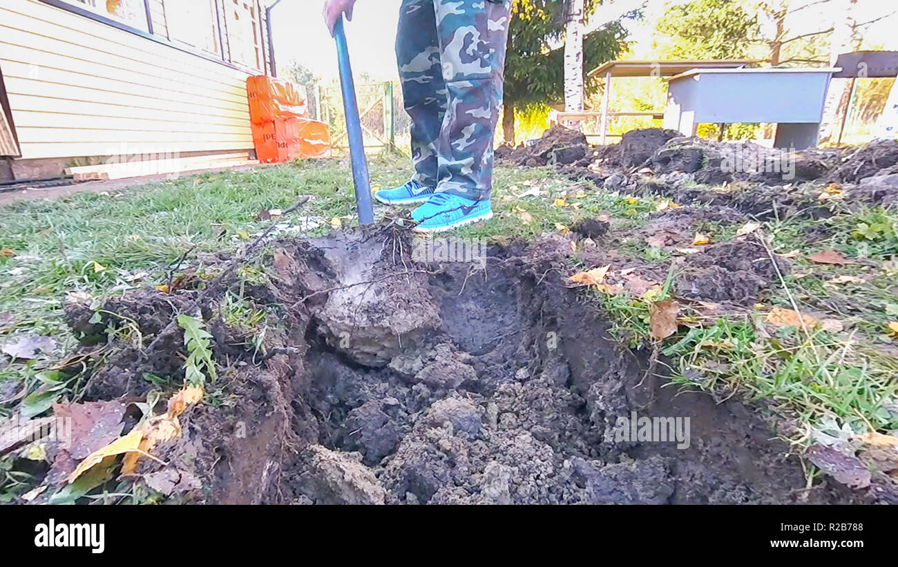 Digging clay in the ground with a shovel in the fall Stock Photo - Alamy