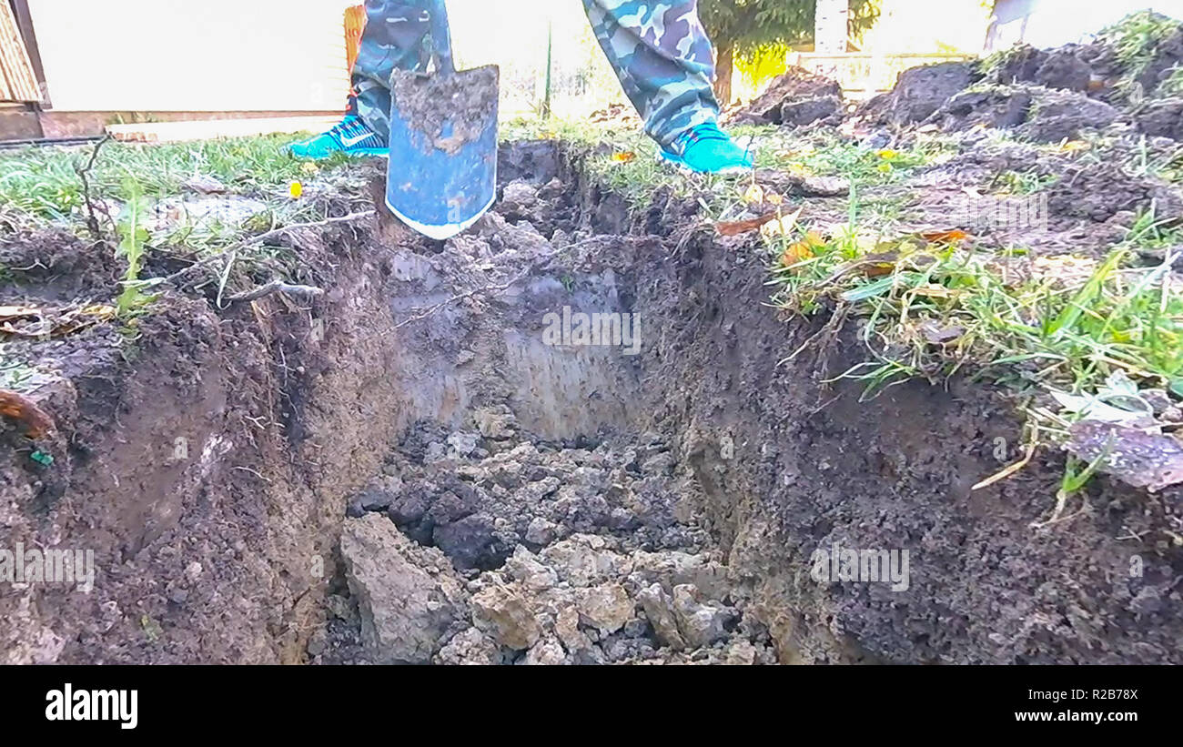 Man digging a ditch with a shovel in autumn Stock Photo - Alamy